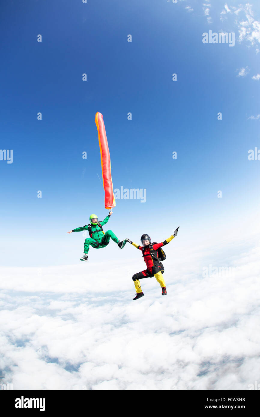 A crazy freefly skydiving team is playing with an air-tube in freefall ...