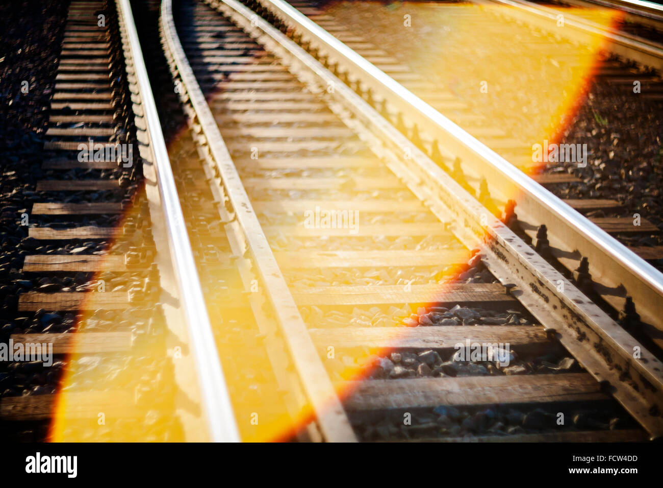 De focused curved railroad tracks with a lens flare. May be used as ...