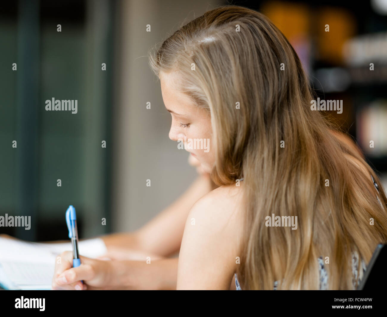 Girl doing her homework in library Stock Photo - Alamy
