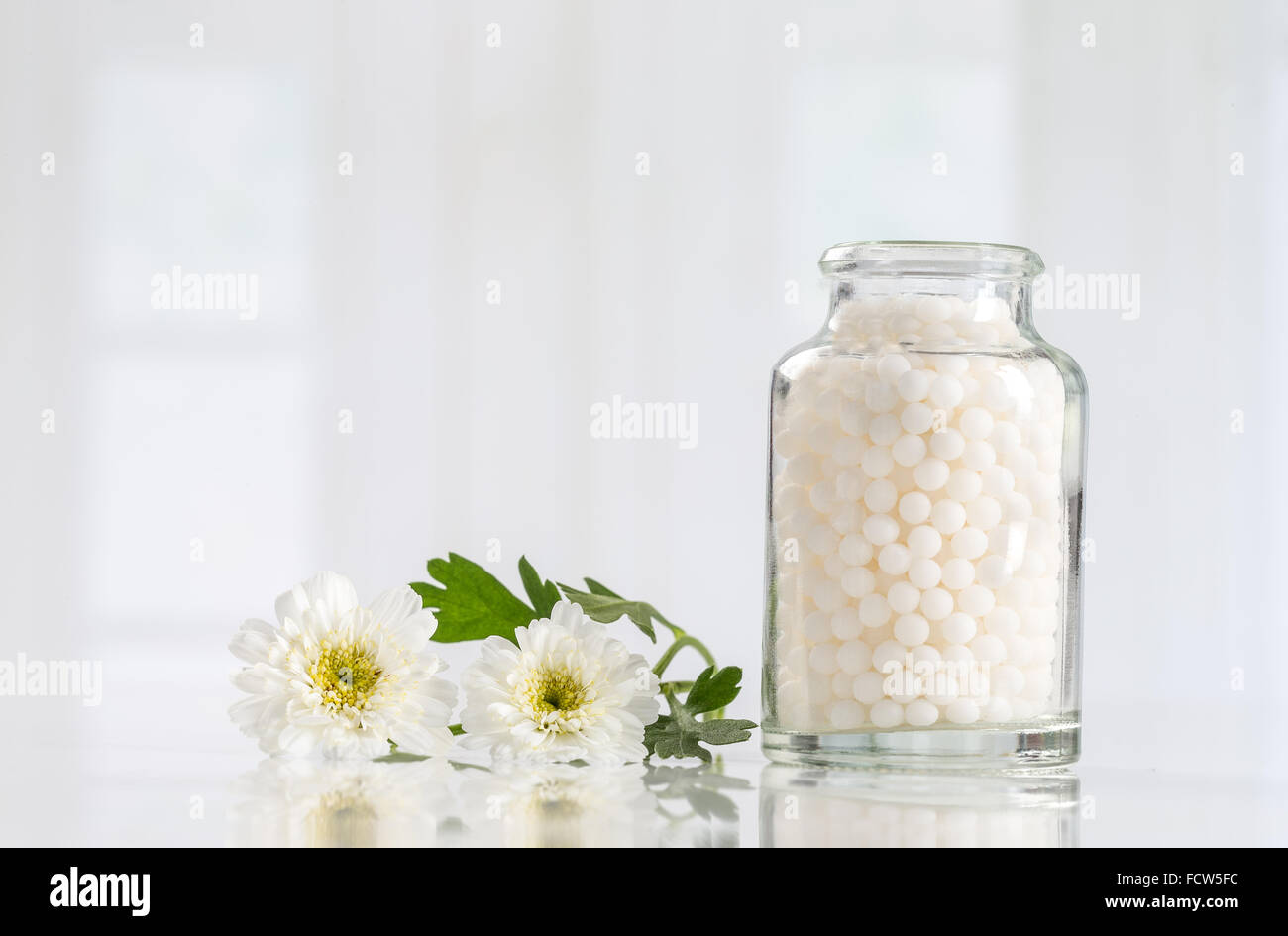 Homeopathy globules with herbal chamomile l flower Stock Photo - Alamy