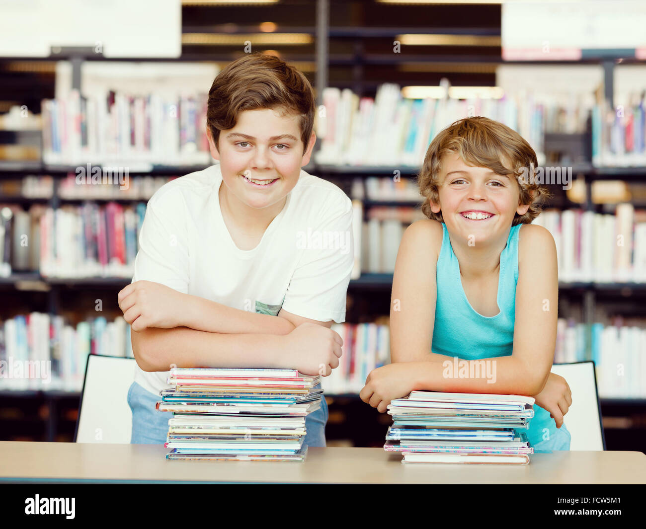 Two boys in library with books Stock Photo - Alamy