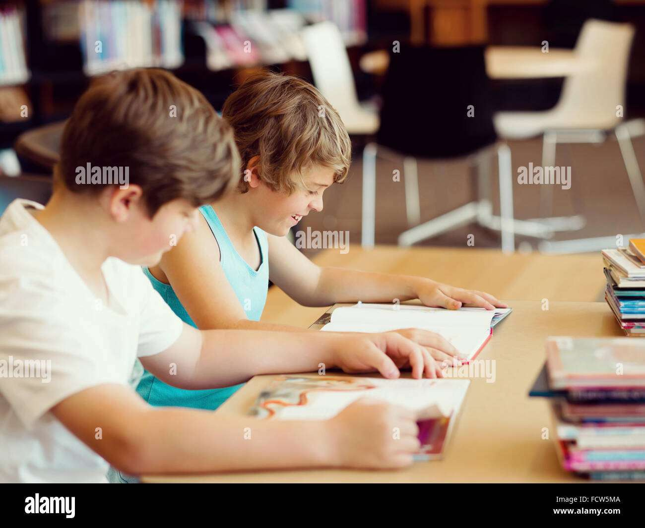Two boys in library with books Stock Photo - Alamy