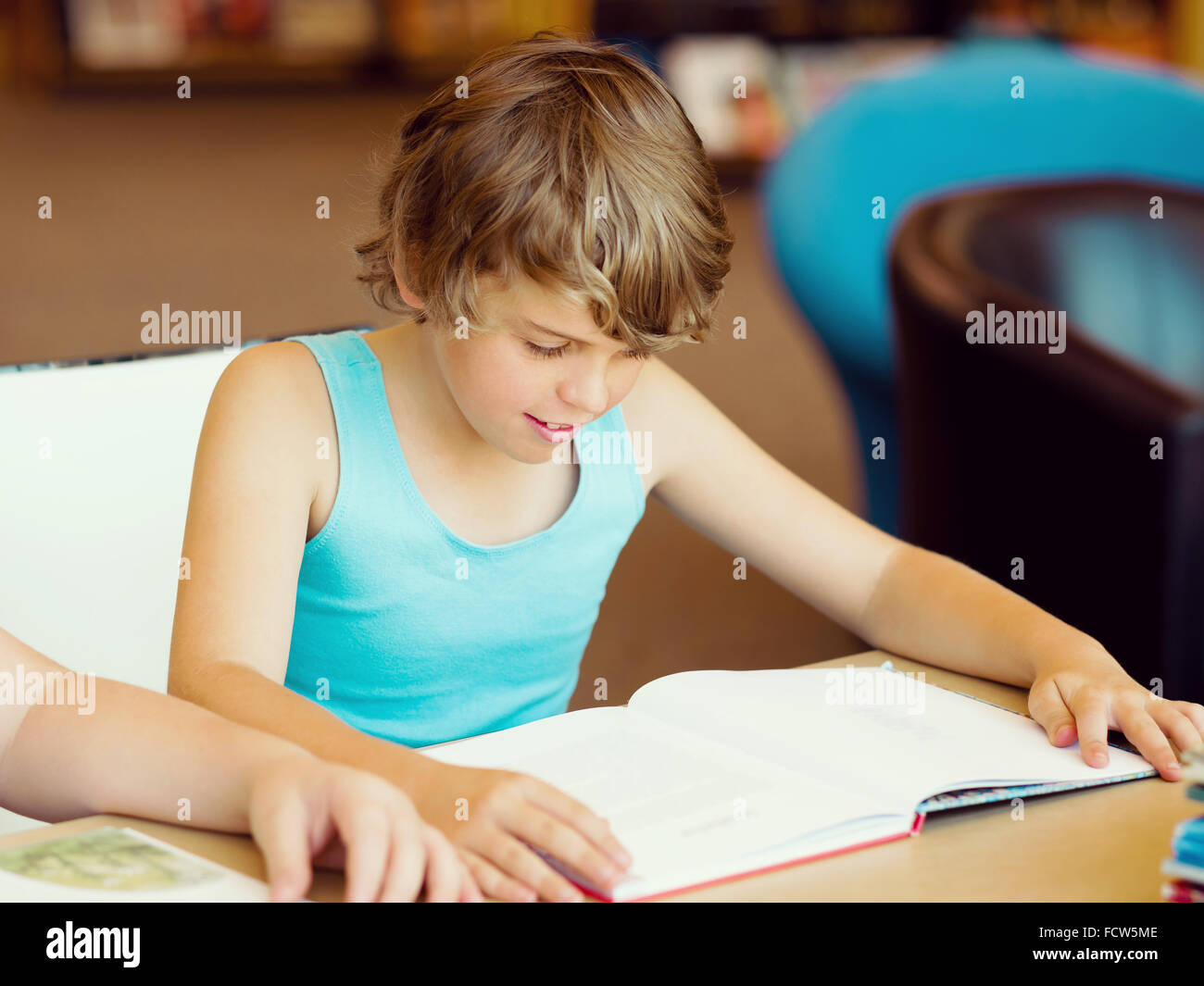 Boy in library with books Stock Photo - Alamy