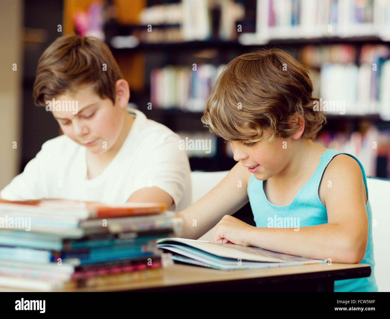Two boys in library with books Stock Photo - Alamy