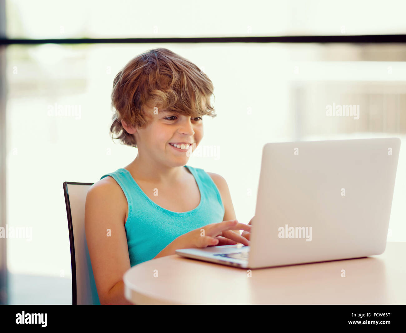 Little boy with laptop in library Stock Photo - Alamy