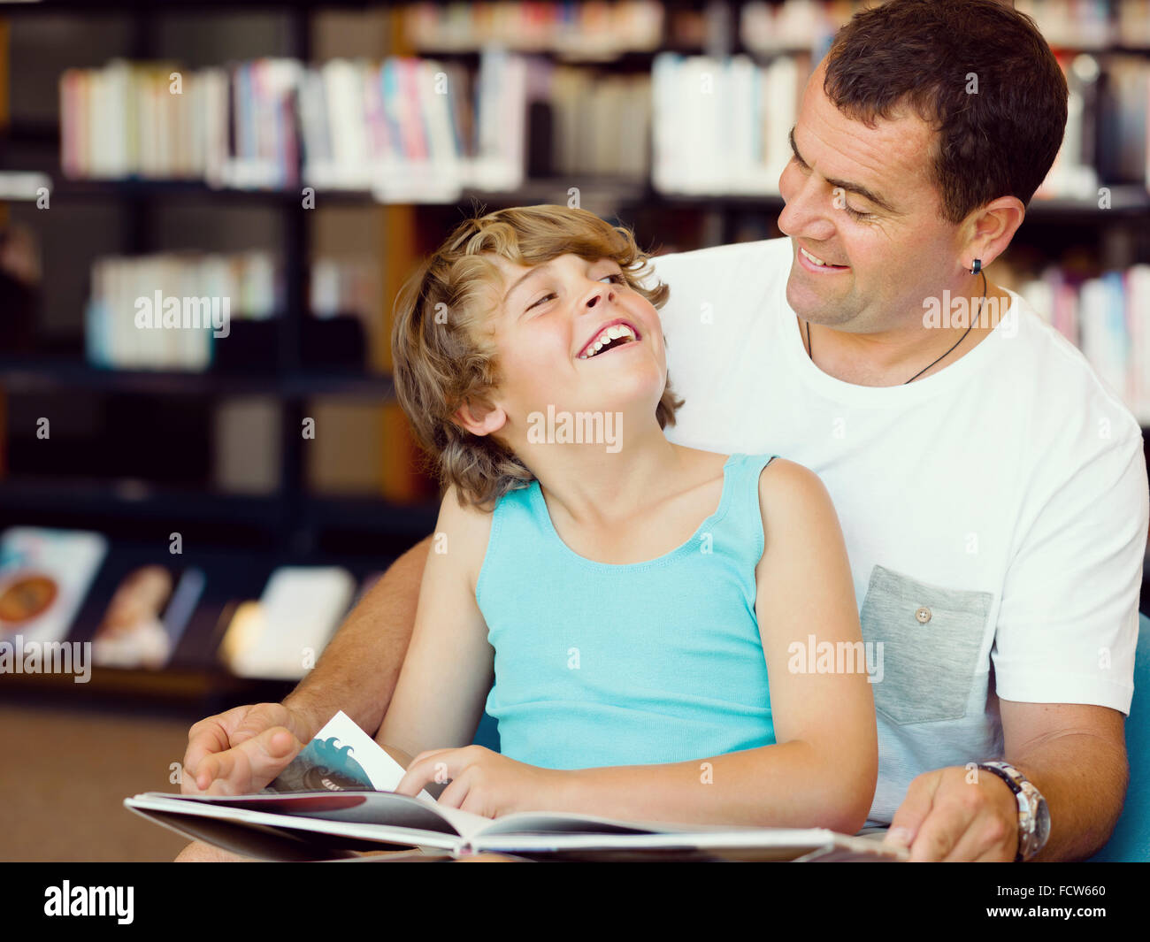 Father with son in library with books Stock Photo - Alamy