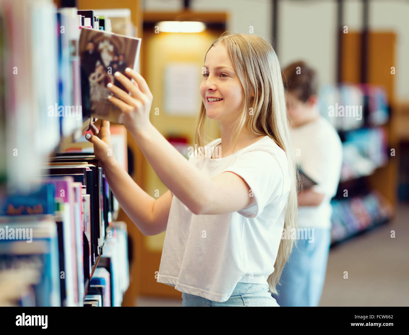 teenage girl in library choosing books Stock Photo - Alamy