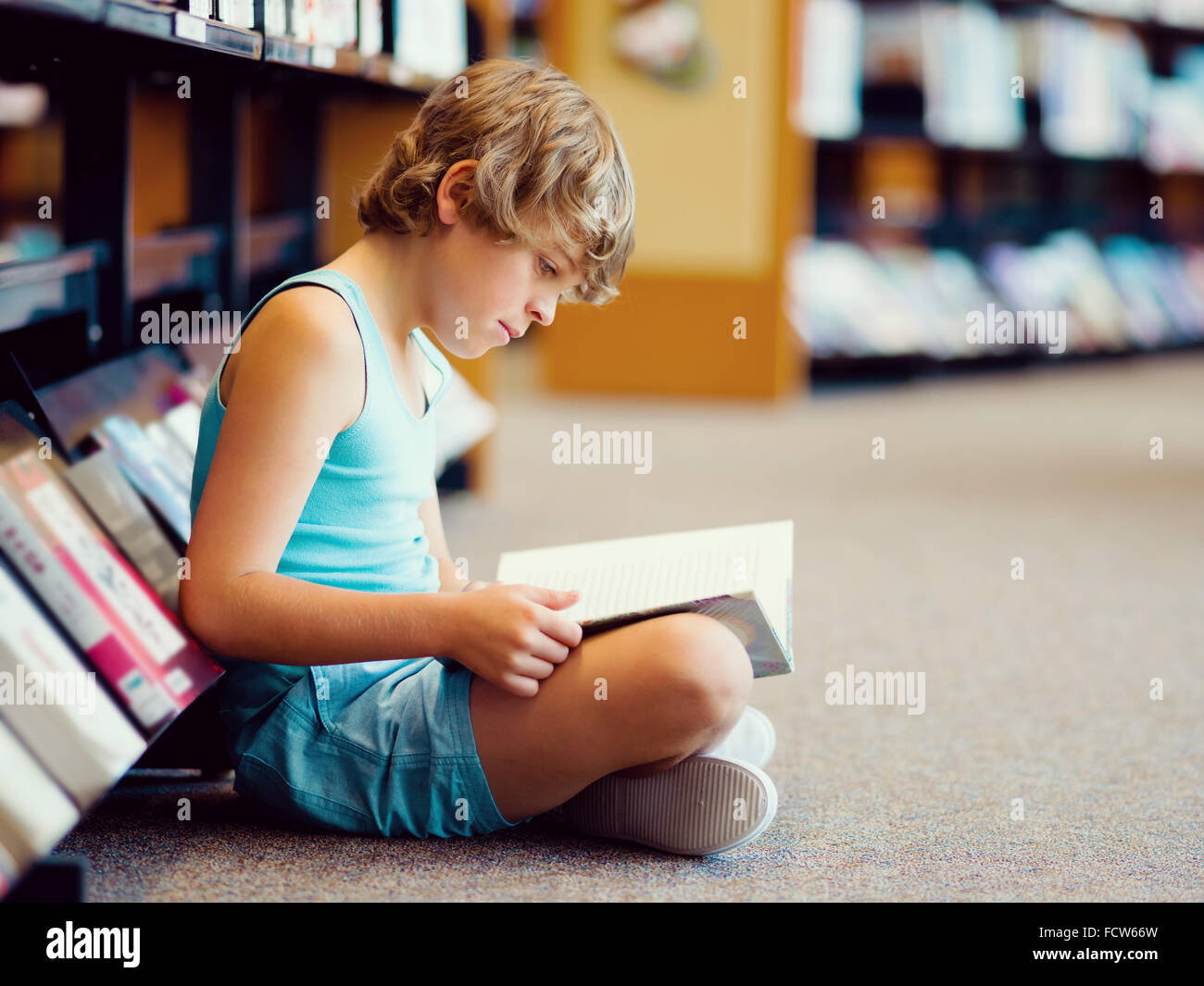 Boy in library with books Stock Photo - Alamy