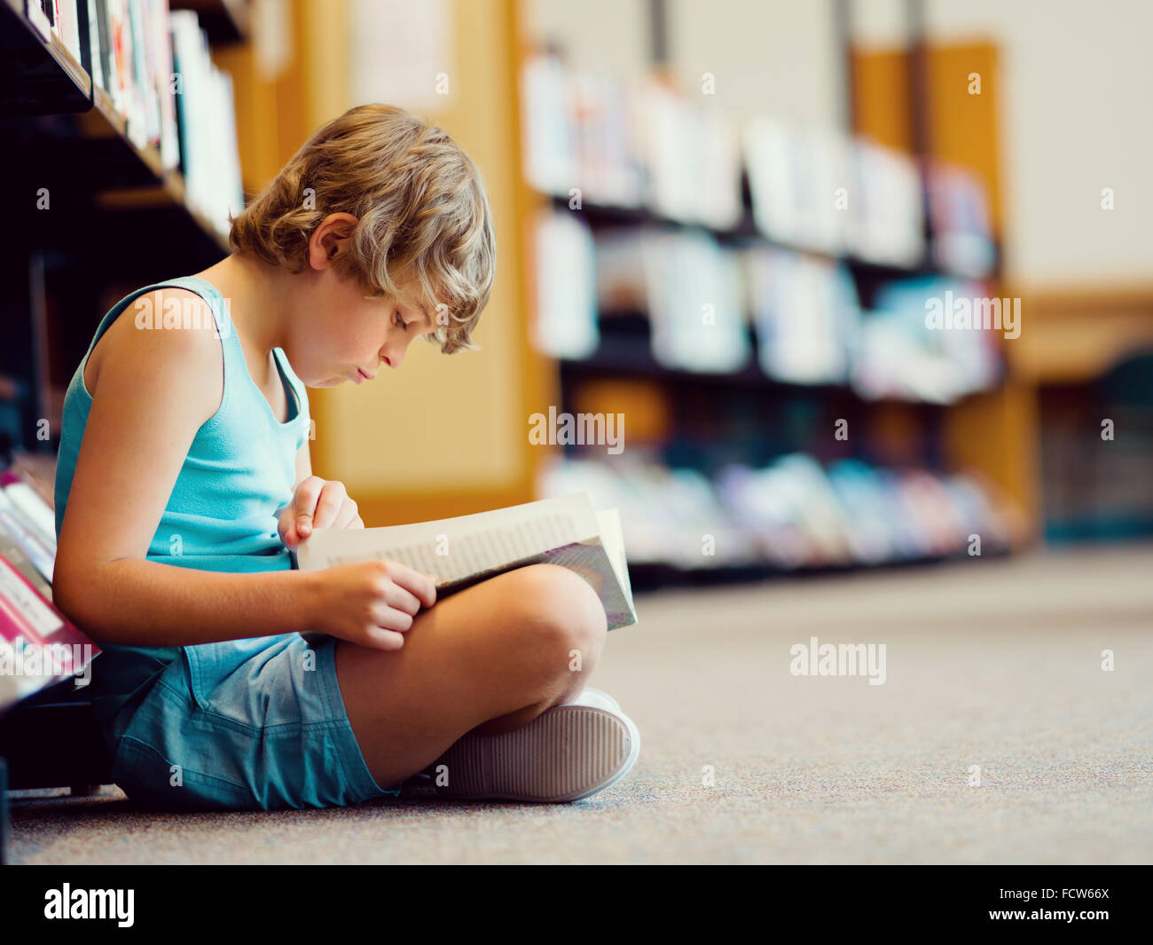 Boy in library with books Stock Photo - Alamy