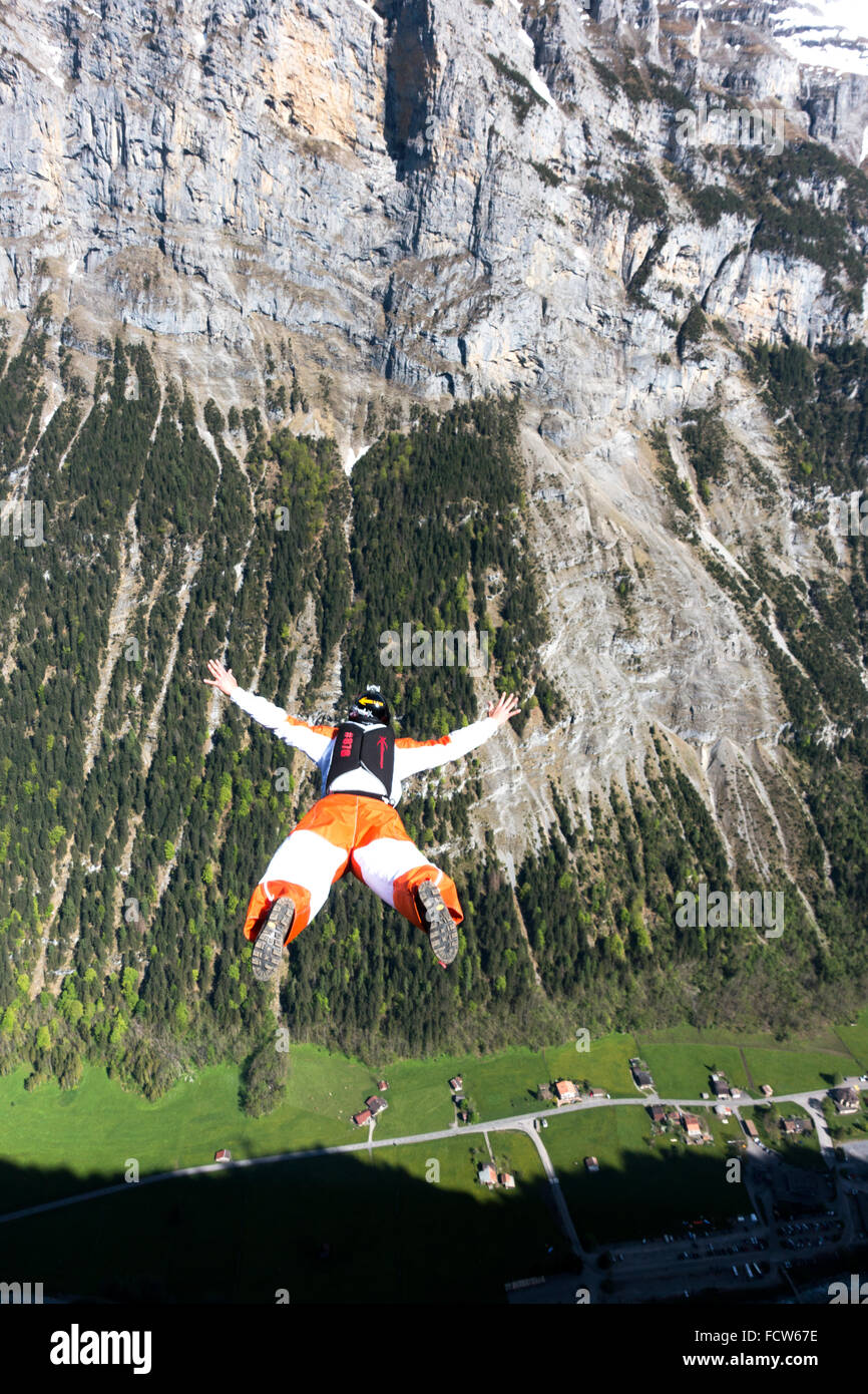 Man is jumping over the edge with his BASE parachute. Soon he has to ...