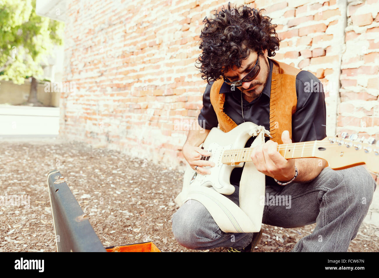A street musician tuning his instrument Stock Photo - Alamy