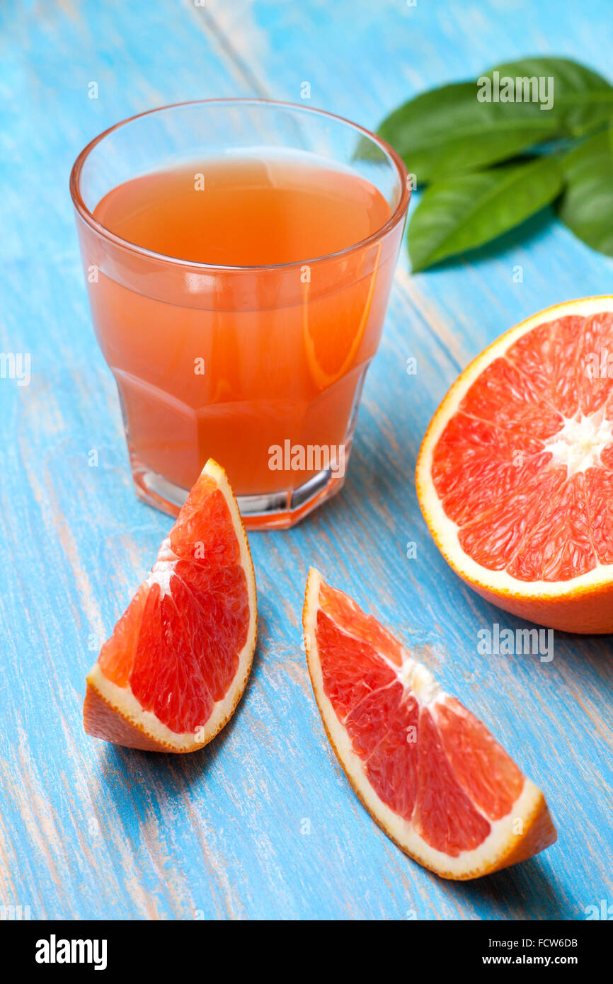 Grapefruit juice and fresh grapefruit on a blue wooden background Stock ...