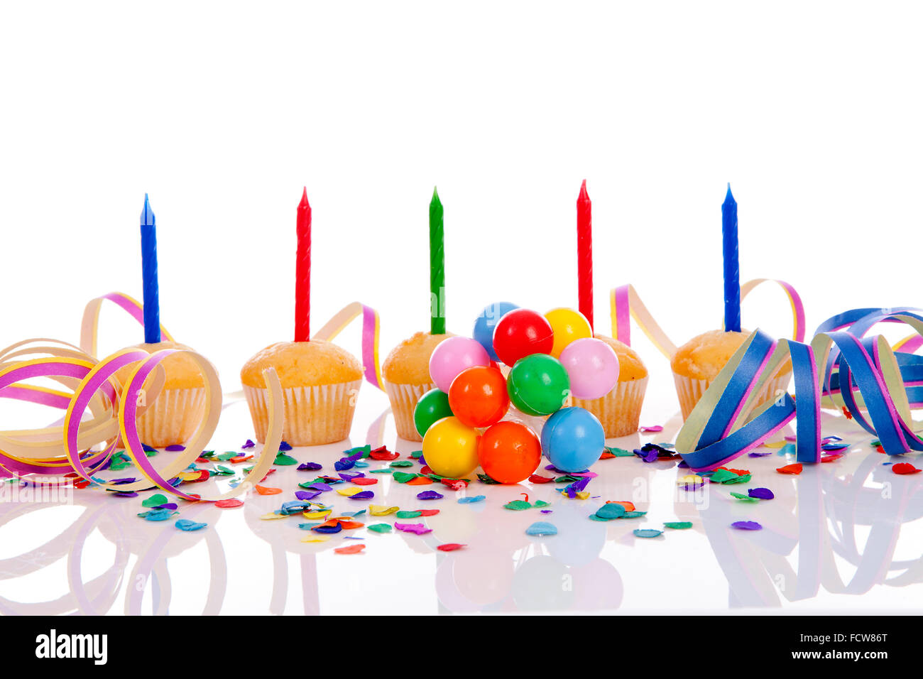 Birthday cupcakes in a row with colorful confetti and balloons over ...