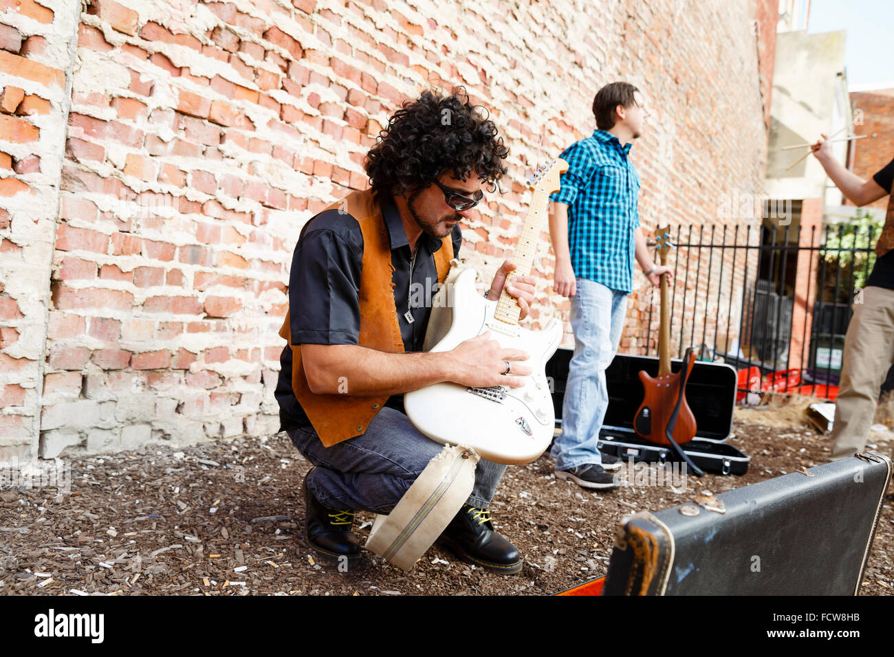 A street musiciam unpacking his guitar Stock Photo - Alamy