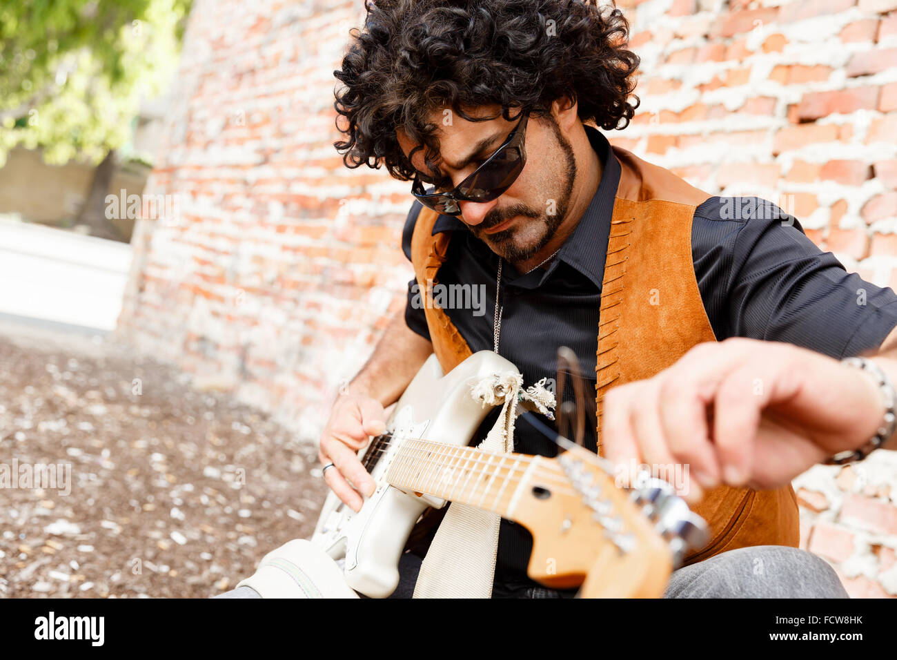 A street musician tuning his instrument Stock Photo - Alamy