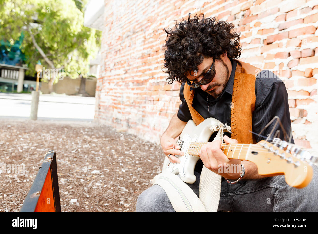 A street musician tuning his instrument Stock Photo - Alamy