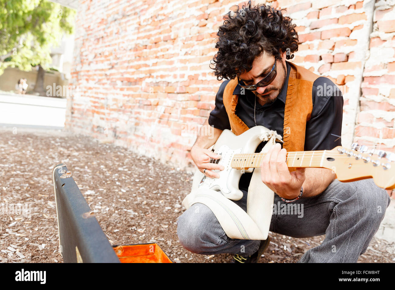 A street musician tuning his instrument Stock Photo - Alamy