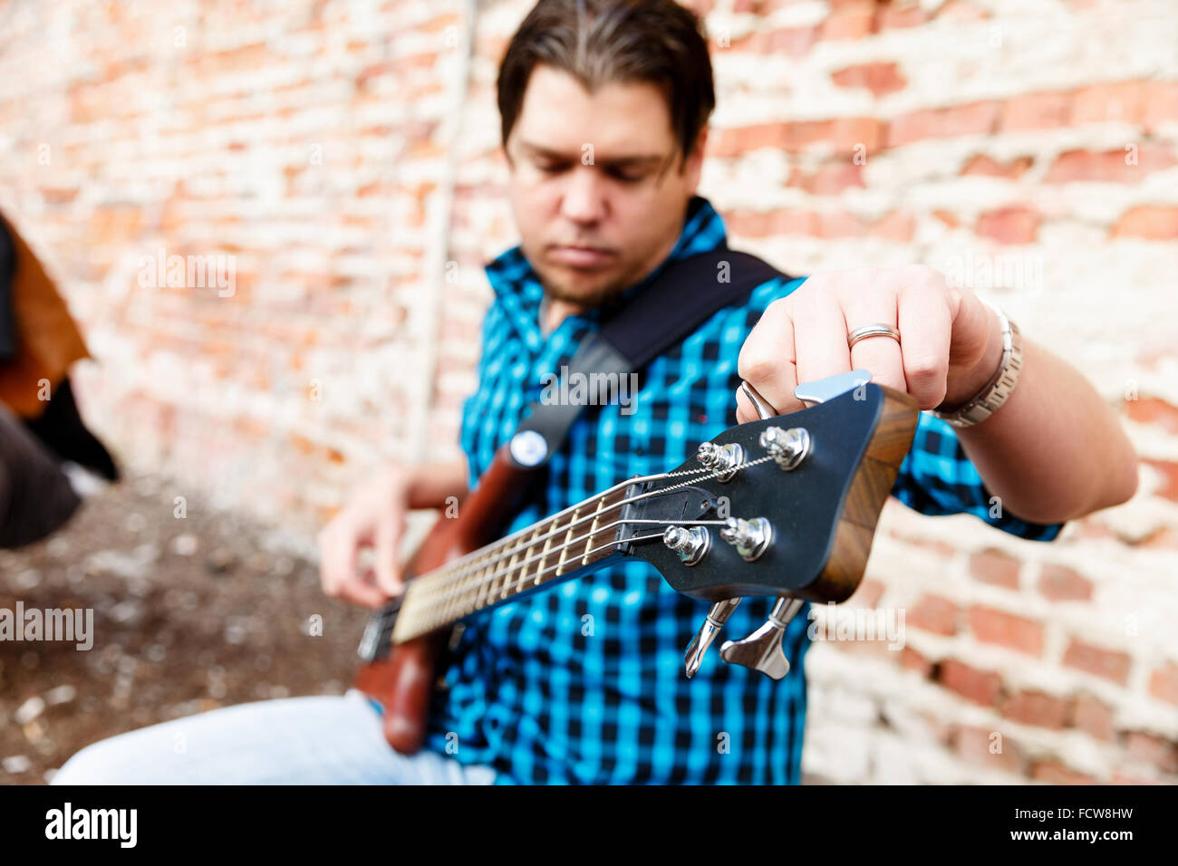 A street musician tuning his instrument Stock Photo - Alamy