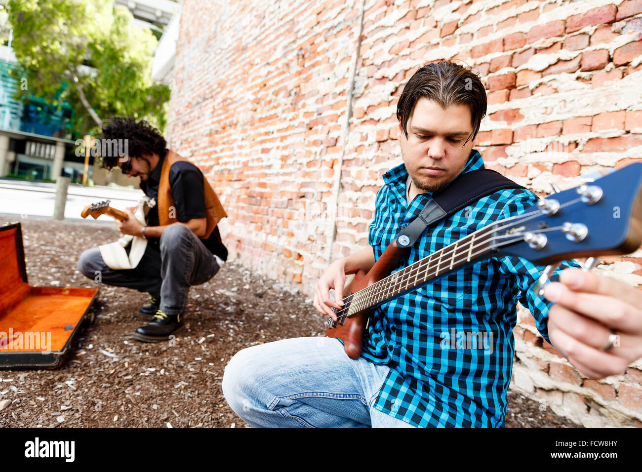 A street musician tuning his instrument Stock Photo - Alamy