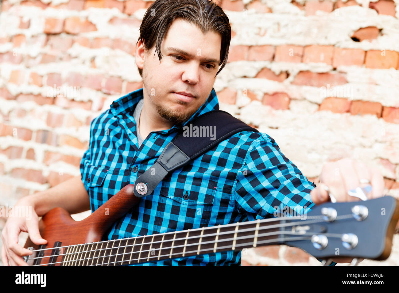 A street musician tuning his instrument Stock Photo - Alamy