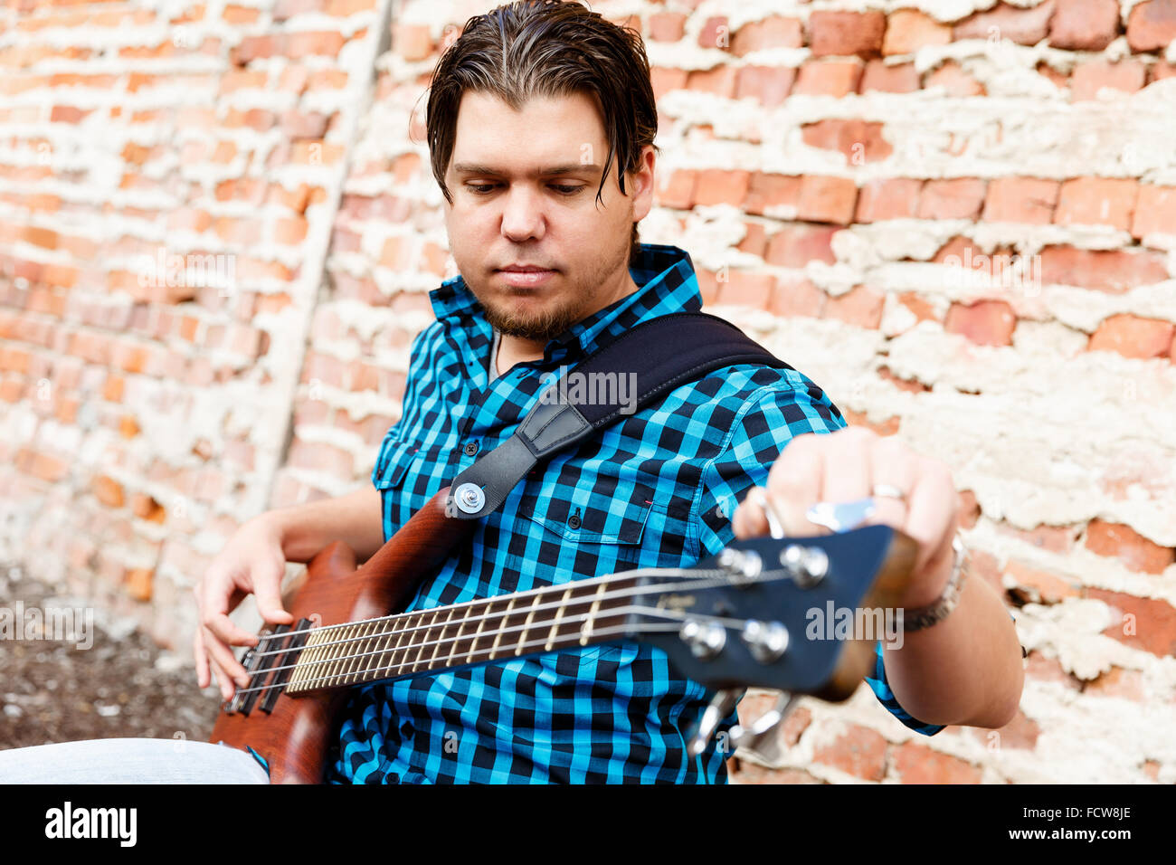 A street musician tuning his instrument Stock Photo - Alamy