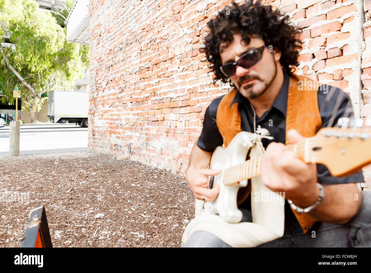 A street musician tuning his instrument Stock Photo - Alamy