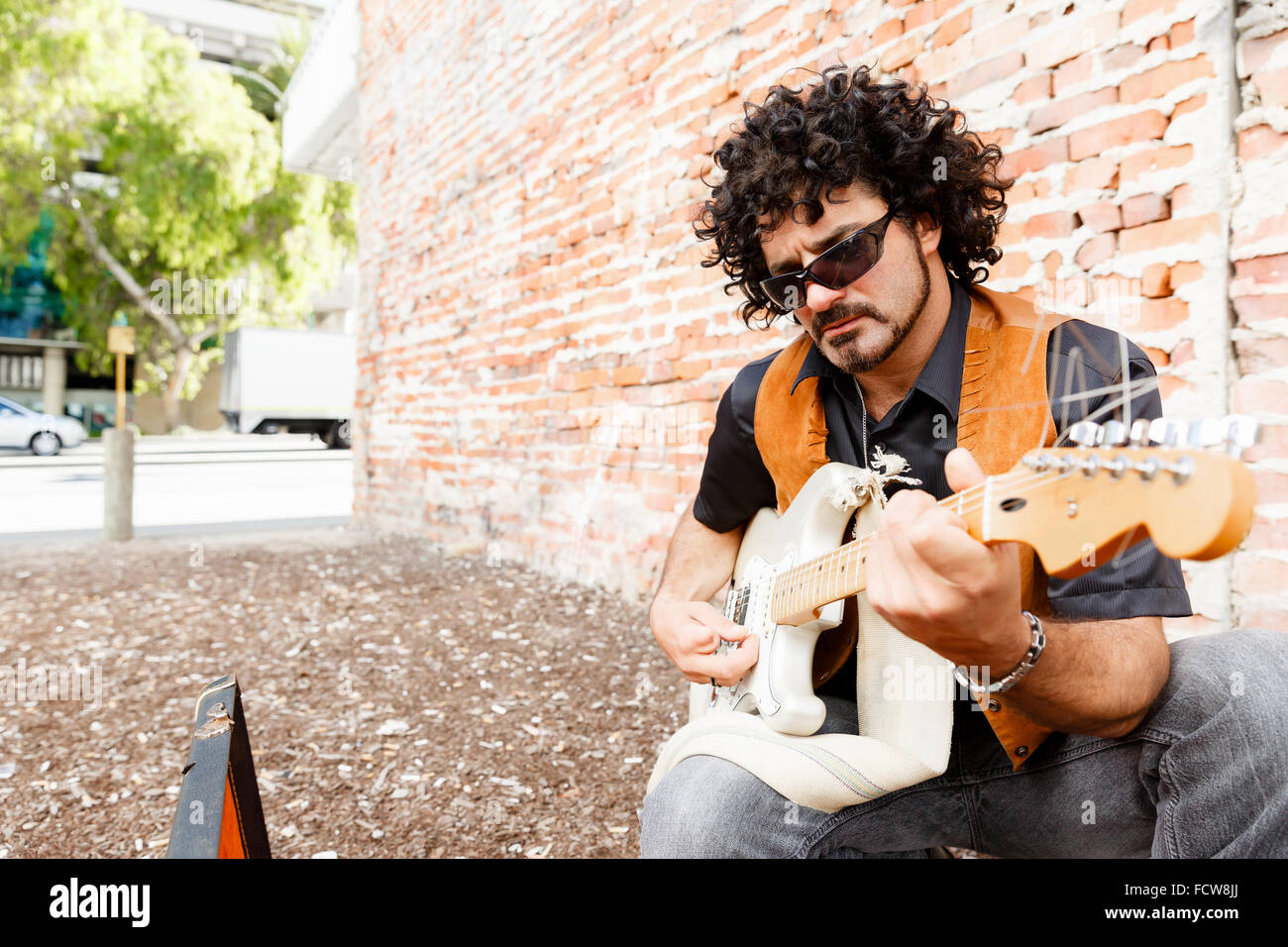 A street musician tuning his instrument Stock Photo - Alamy