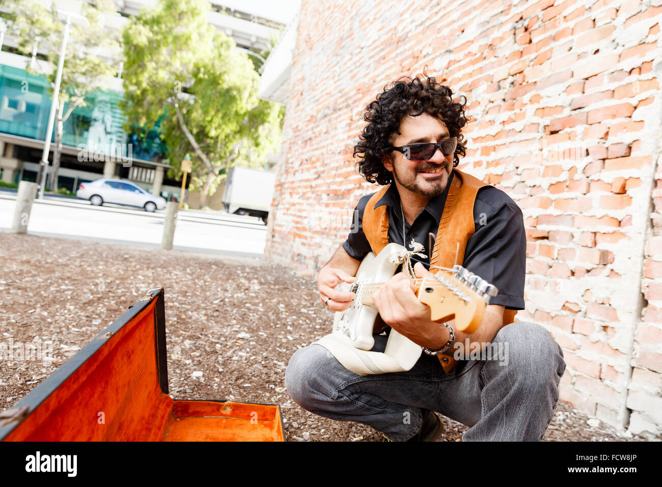 A street musician tuning his instrument Stock Photo - Alamy