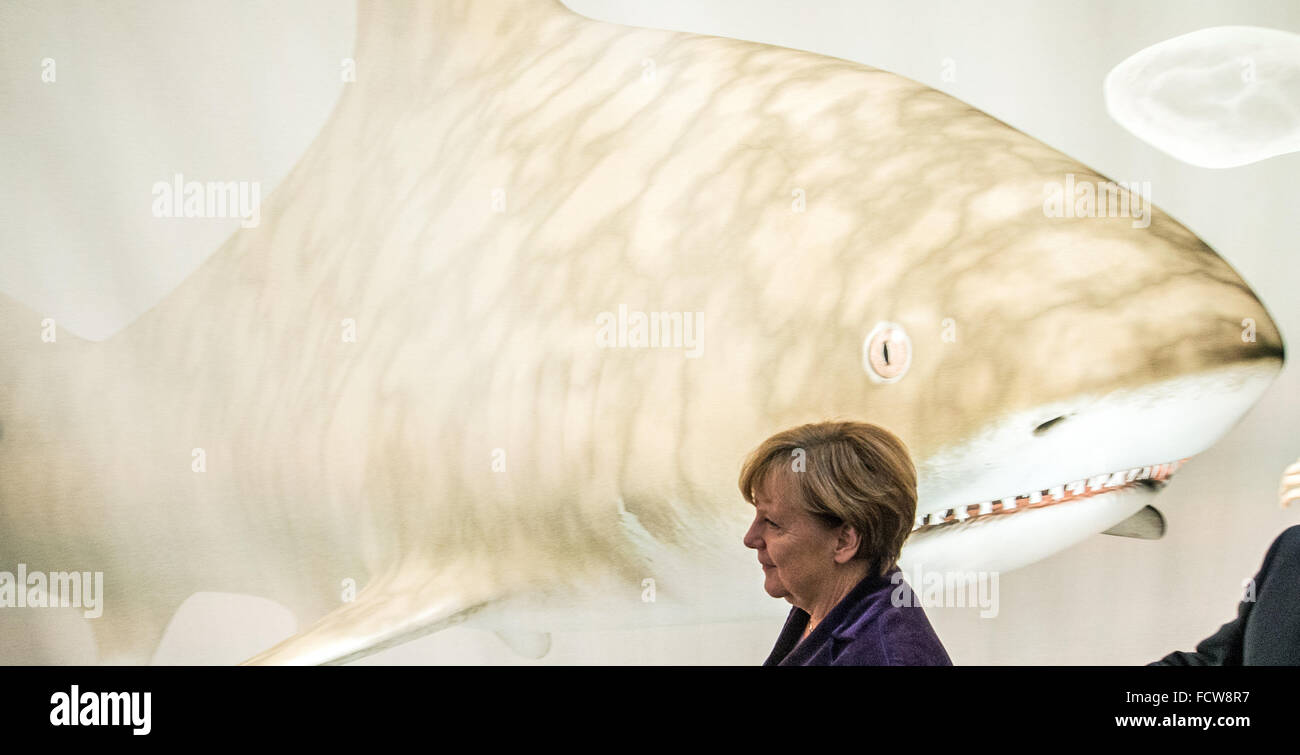 German Chancellor Angela Merkel walks past a wall image depicting a ...