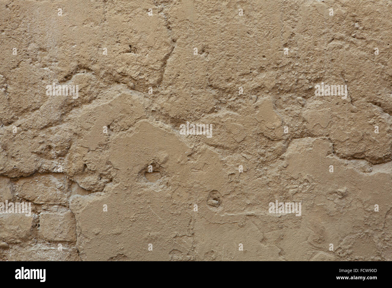 Old ochre painted stucco wall with cracked plaster. Background texture ...