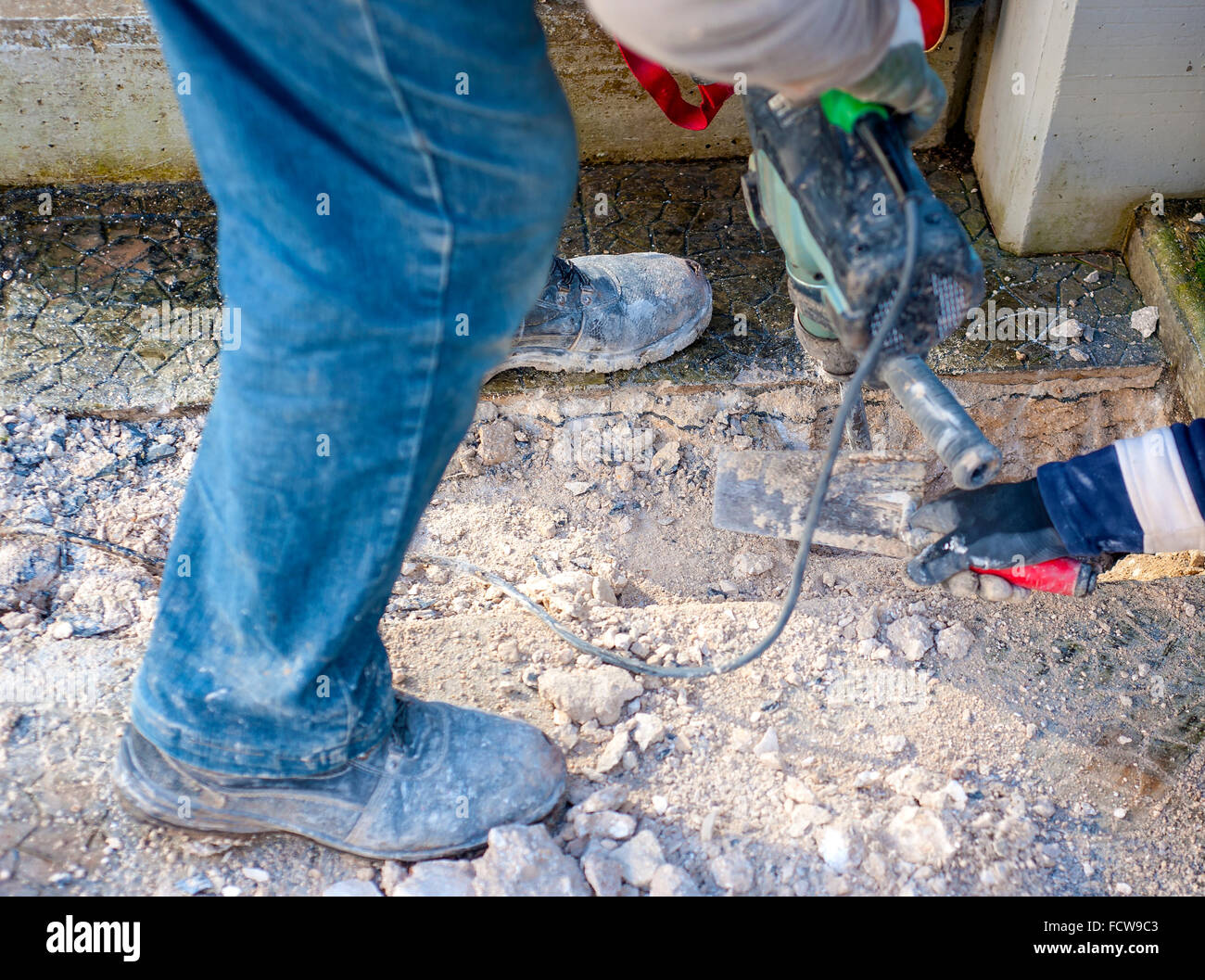 Construction site - workers using Jackhammer and trowel performing ...