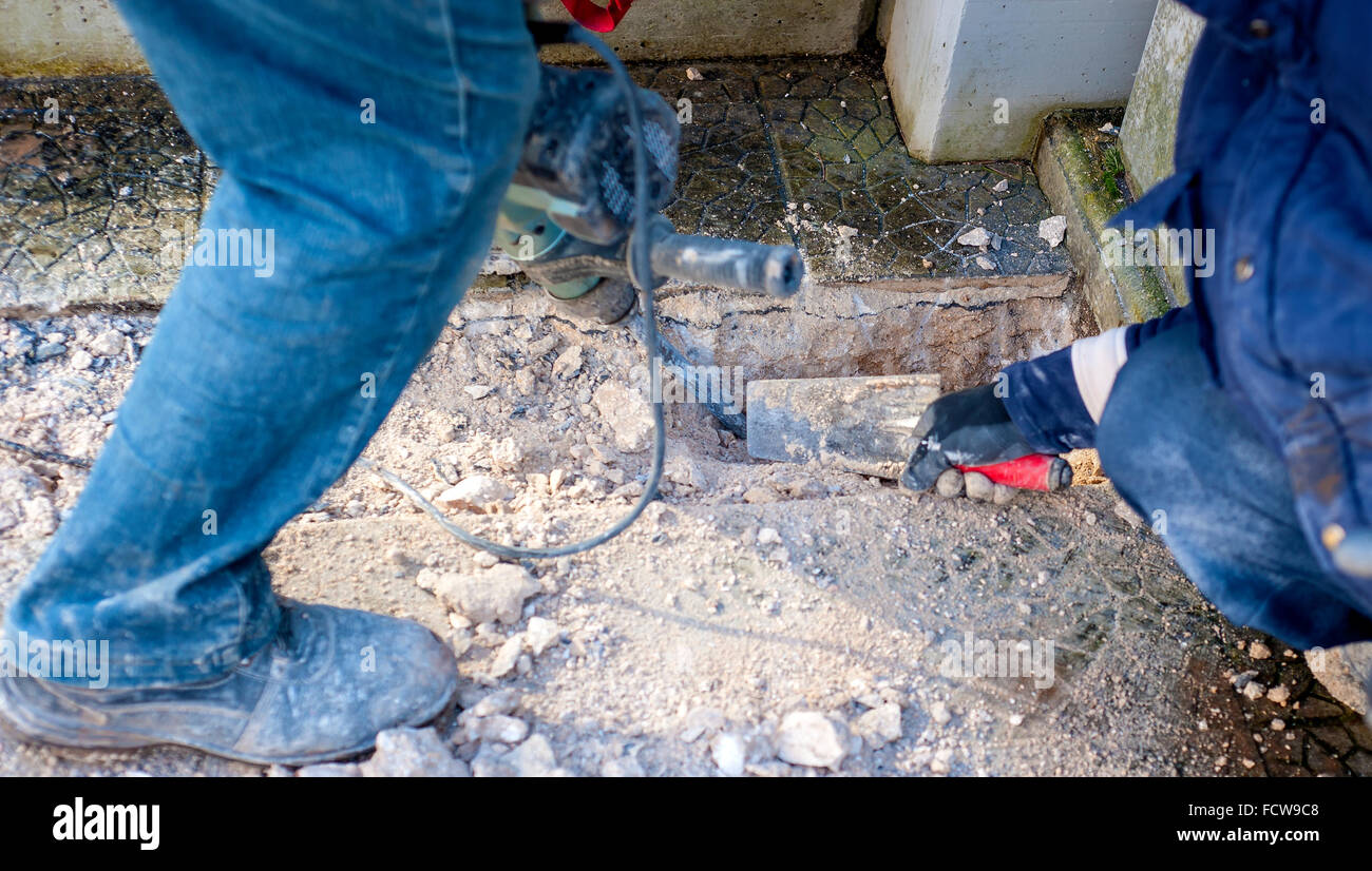 Construction site - workers using Jackhammer and trowel performing ...