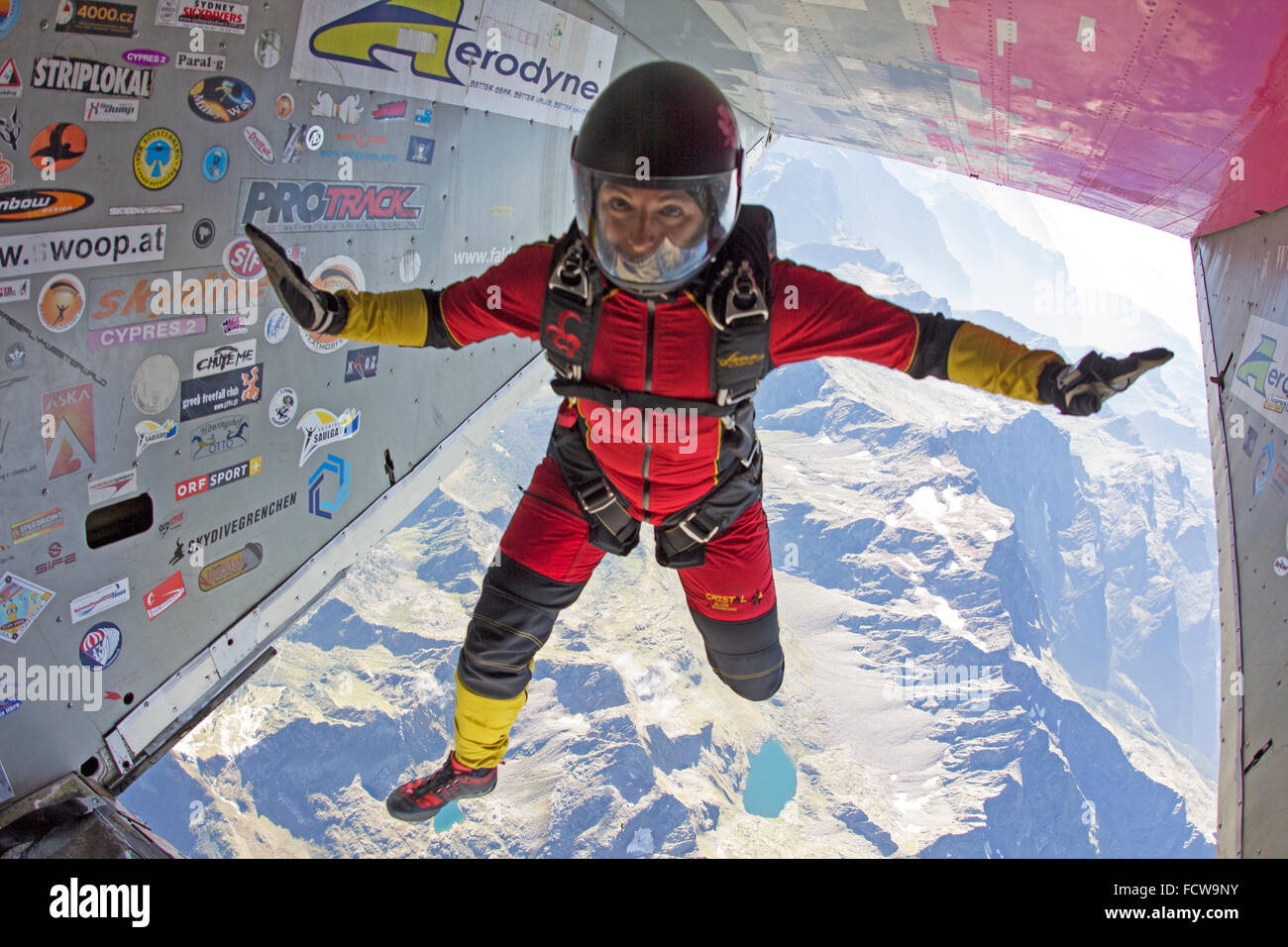 A Skydiver woman is jumping out of a plane...backwards into freefall ...