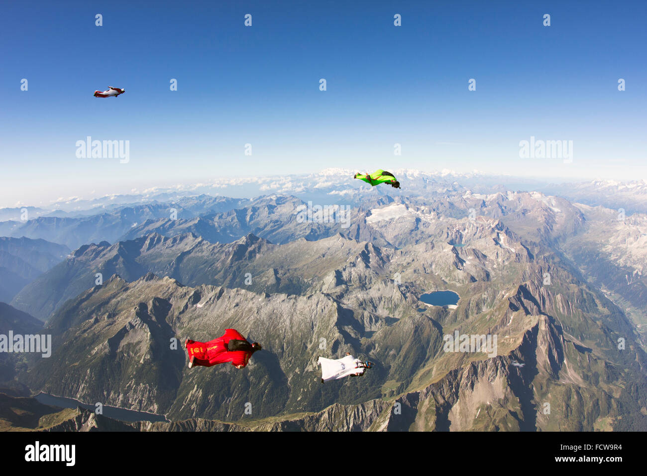 Wingsuit pilots are flying in a group formation together. Thereby the ...