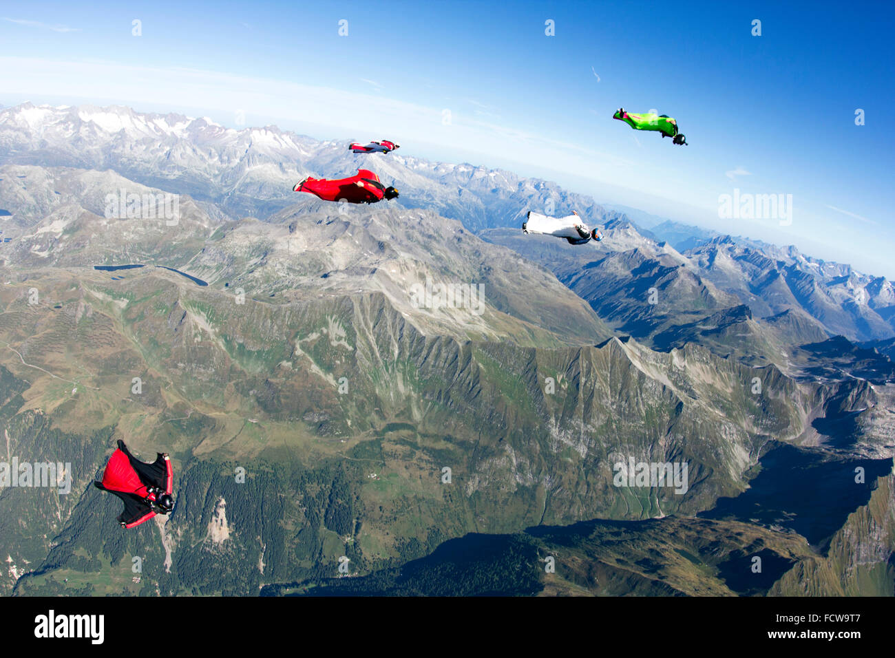 Wingsuit pilots are flying in a group formation together. Thereby the ...