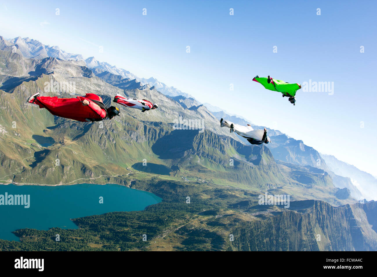 Wingsuit pilots are flying in a group formation together. Thereby the ...