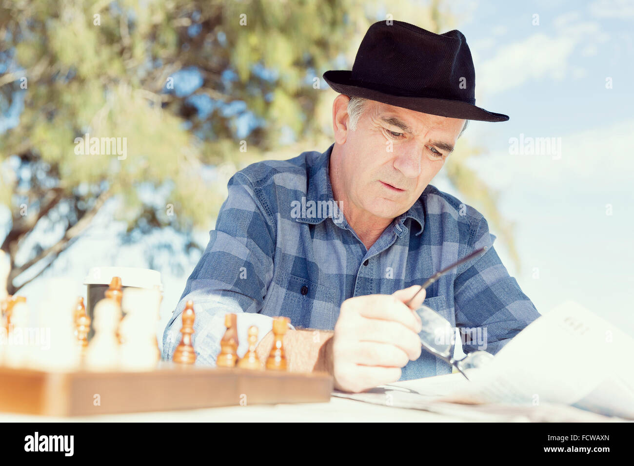 Senior gentleman reading newspaper in park Stock Photo - Alamy