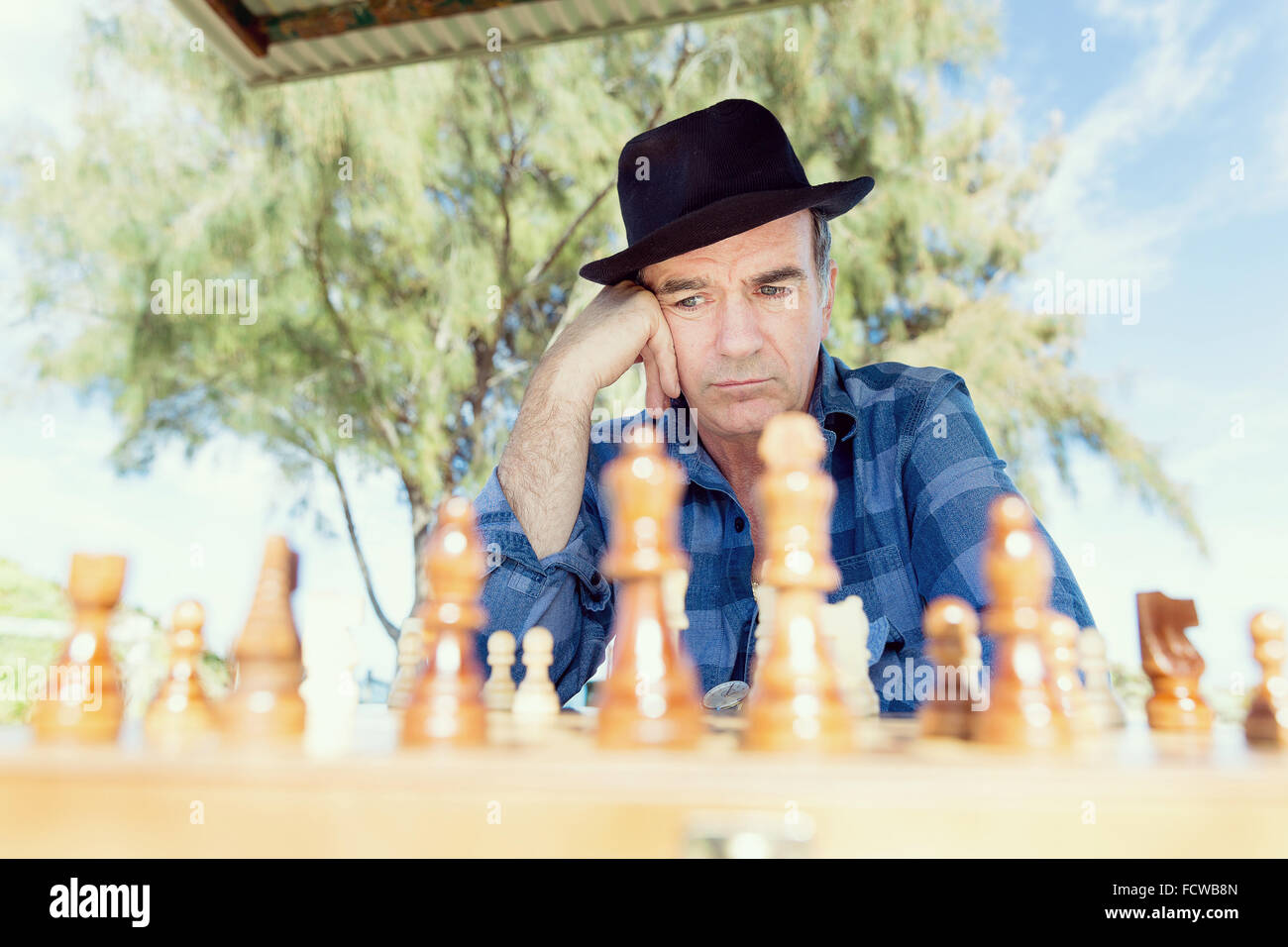 Elderly man sitting outdoors with chess Stock Photo - Alamy