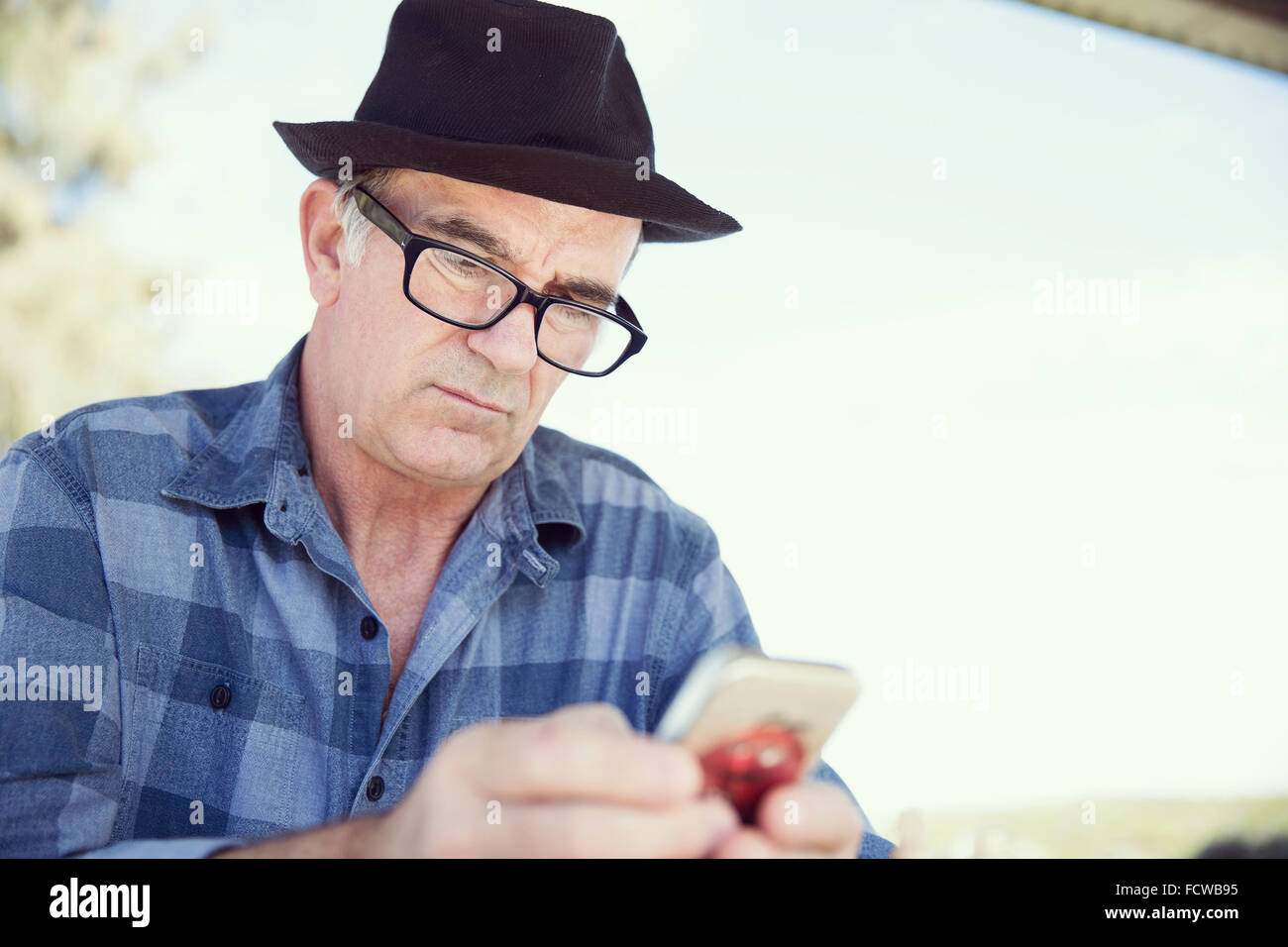 Portrait of an old man with his mobile phone outdoors Stock Photo - Alamy