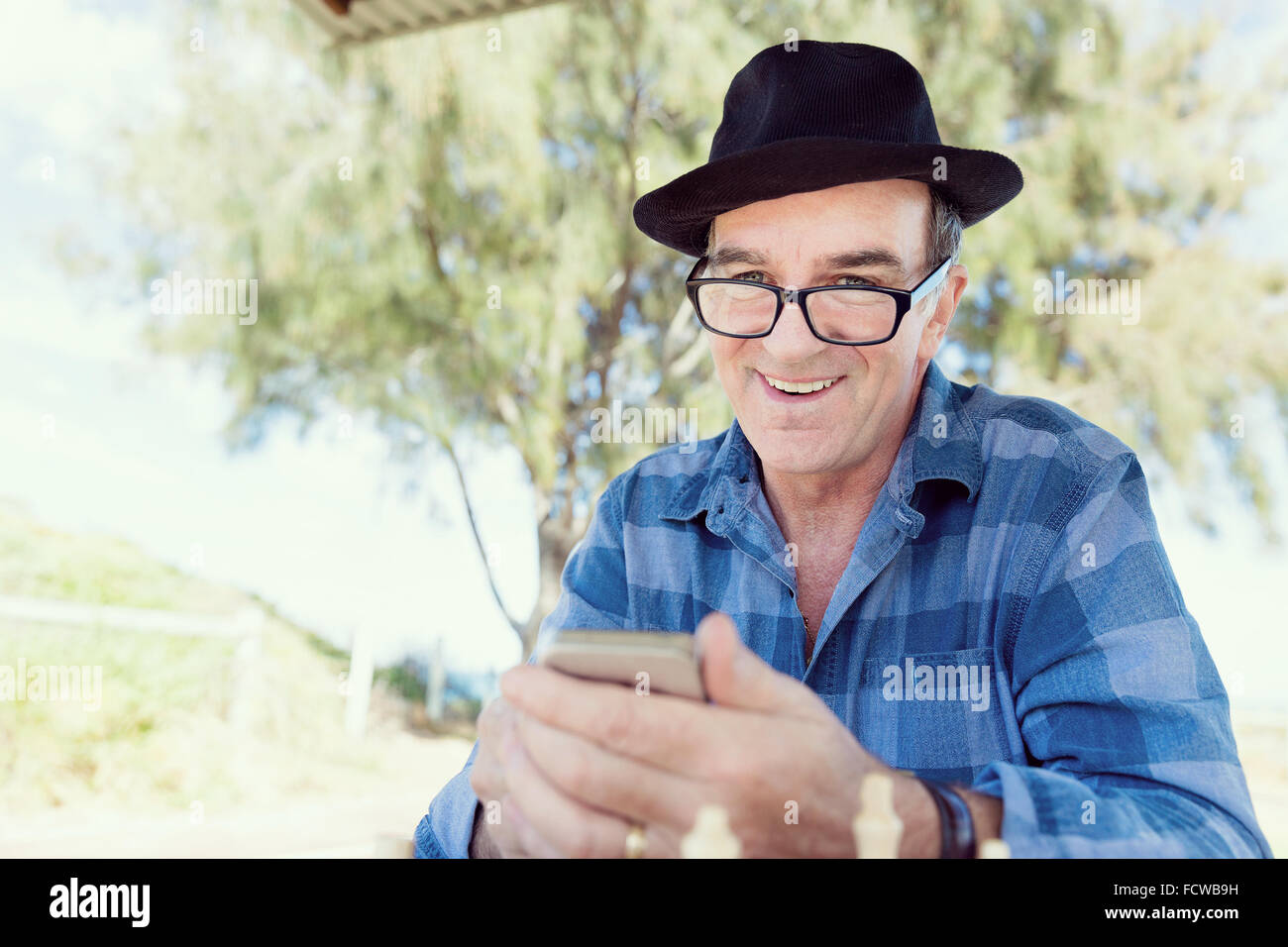 Portrait of an old man with his mobile phone outdoors Stock Photo - Alamy
