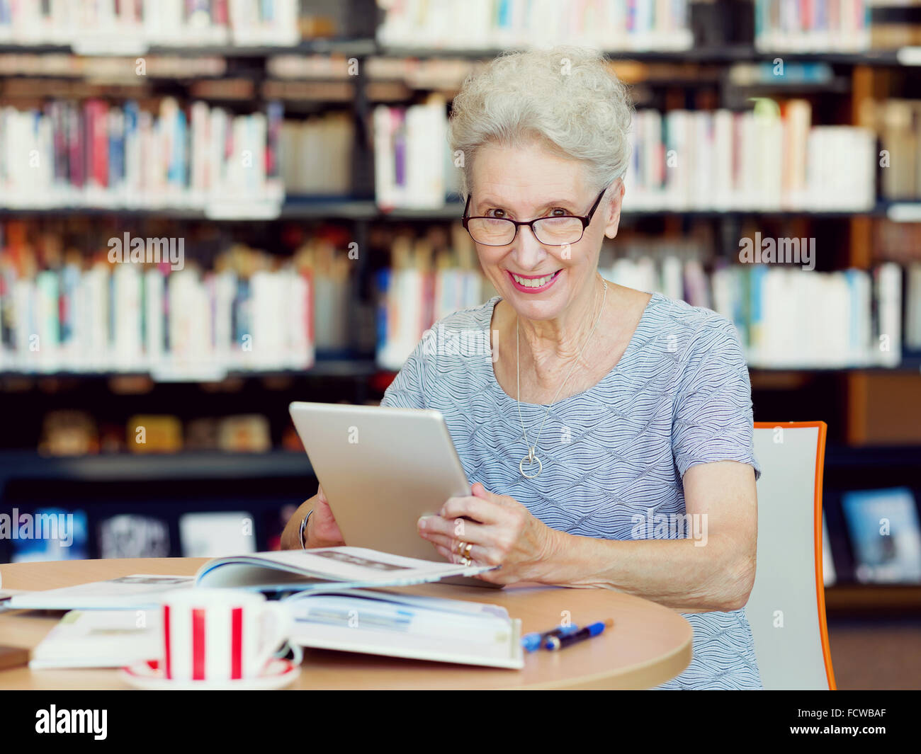 Elderly lady working with tablet Stock Photo - Alamy