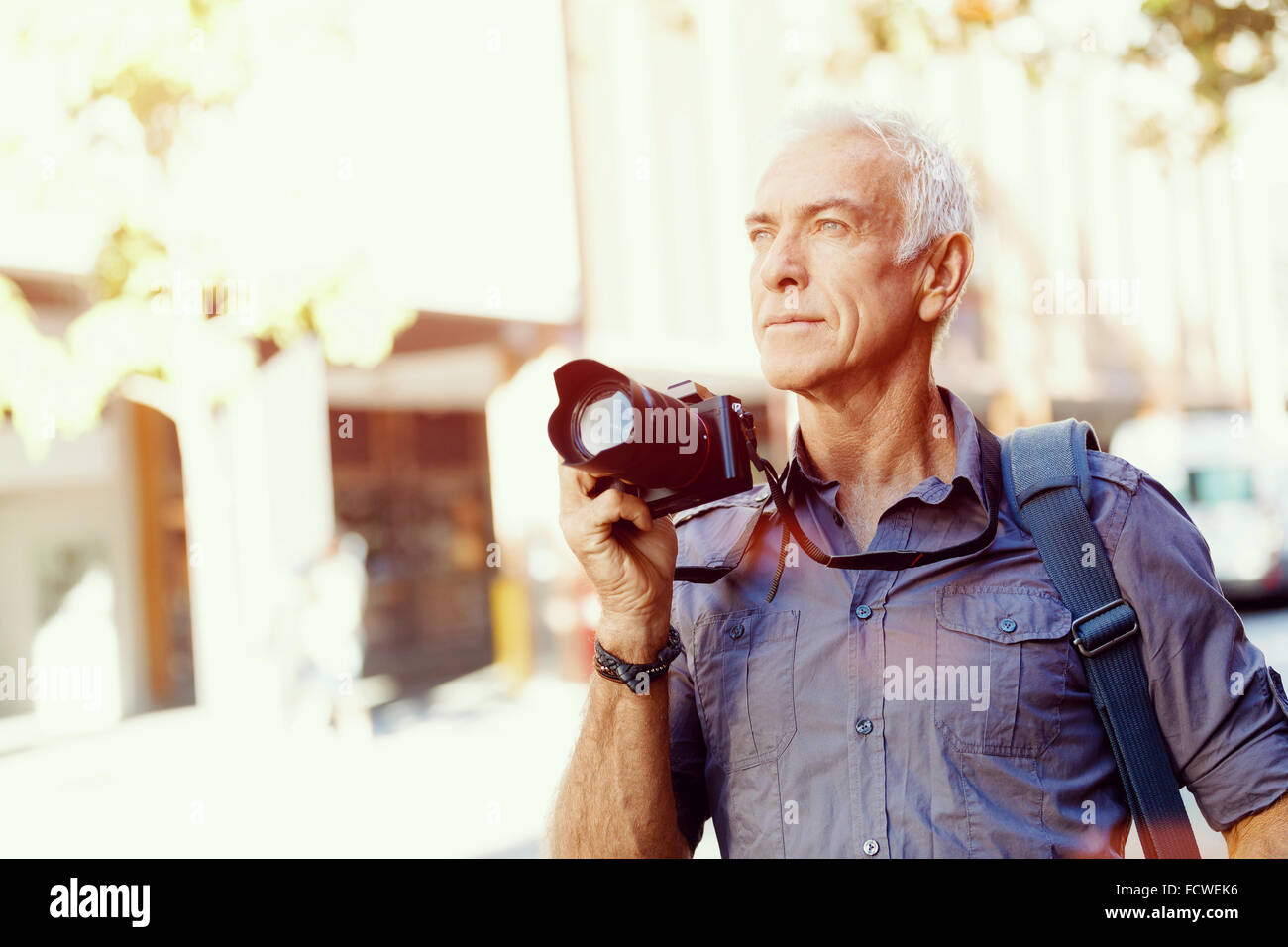 Senior man with camera in city Stock Photo - Alamy