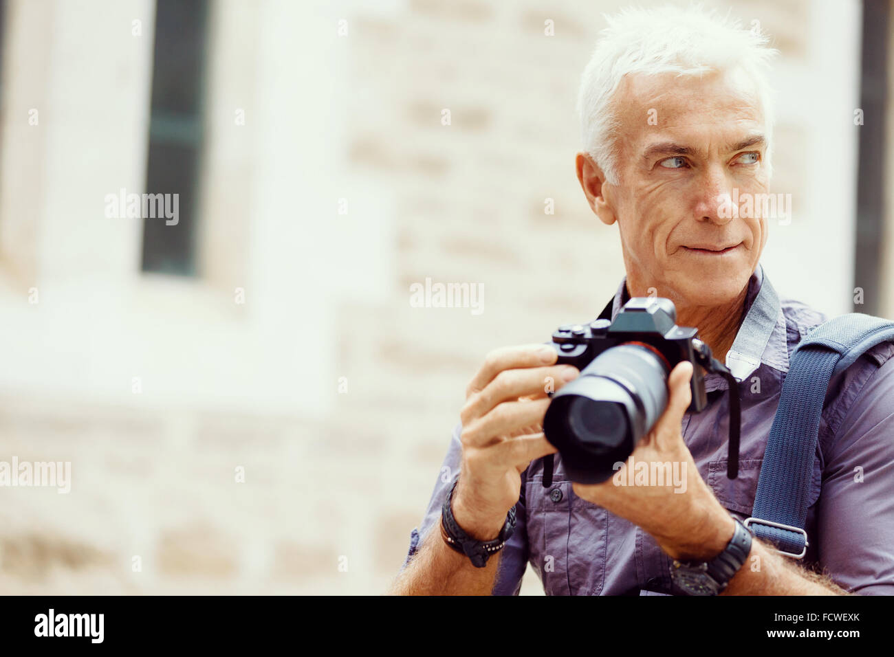 Senior man with camera in city Stock Photo - Alamy