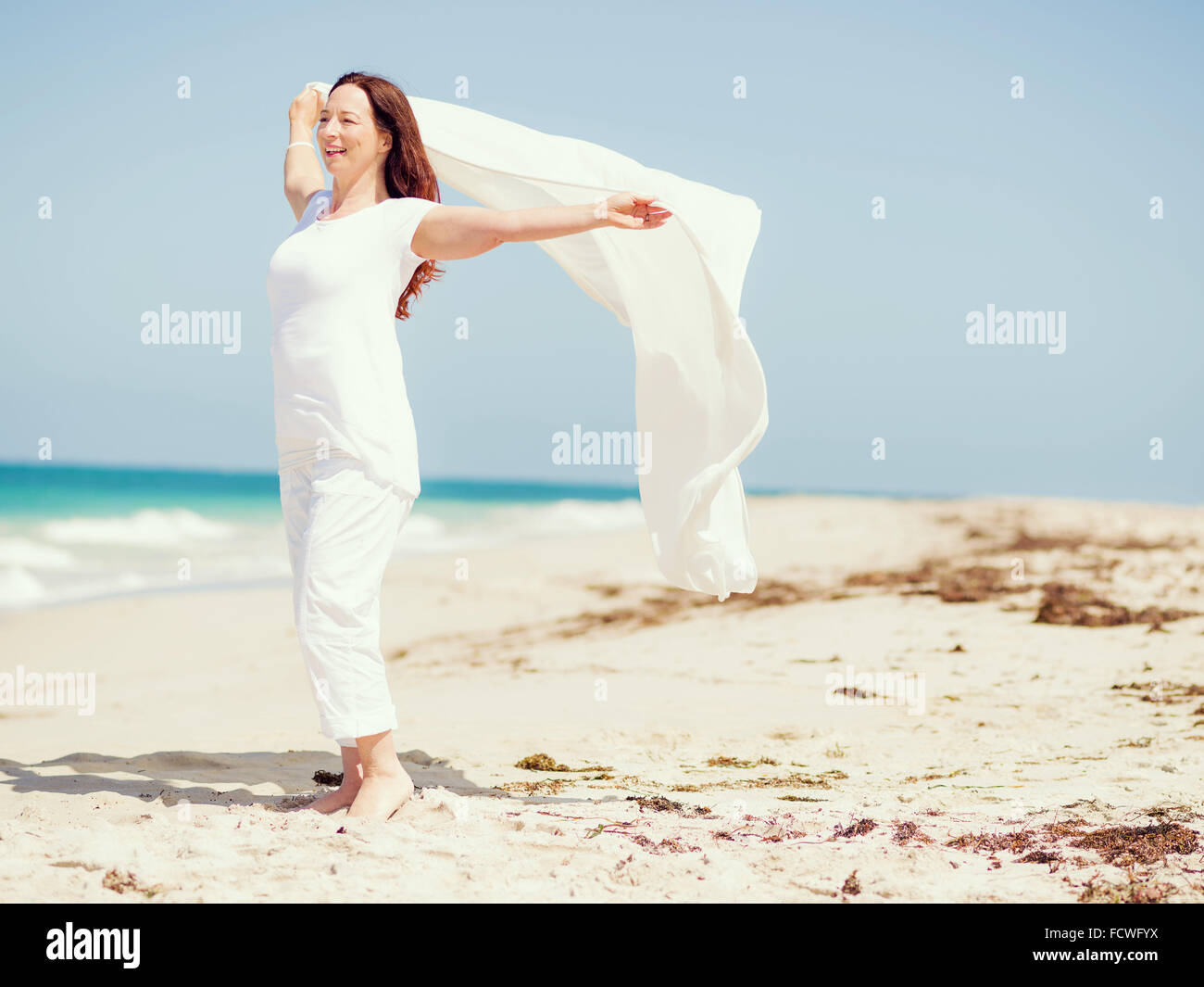 Woman in white clothes on the beach on sunny day Stock Photo - Alamy