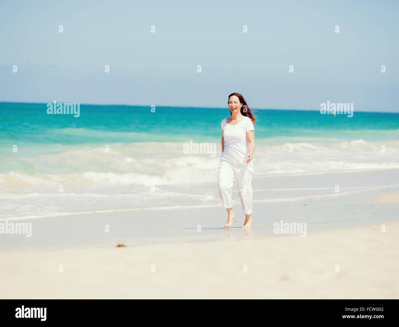 Woman in white clothes on the beach on sunny day Stock Photo - Alamy