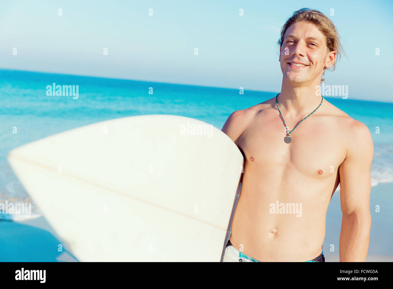 A young surfer with his board on the beach Stock Photo - Alamy
