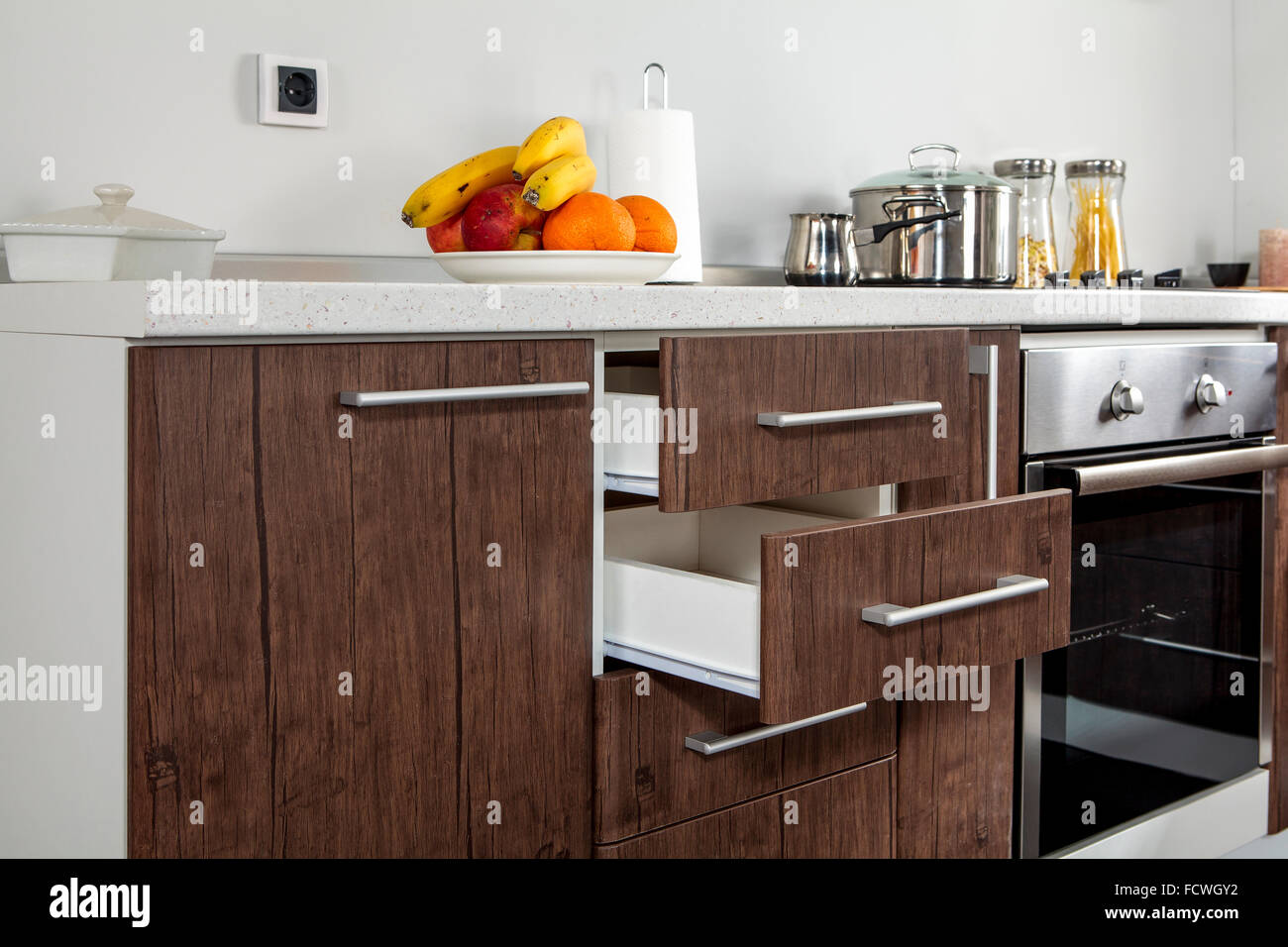 Part of modern kitchen with electric stove oven, drawers, handle and ...