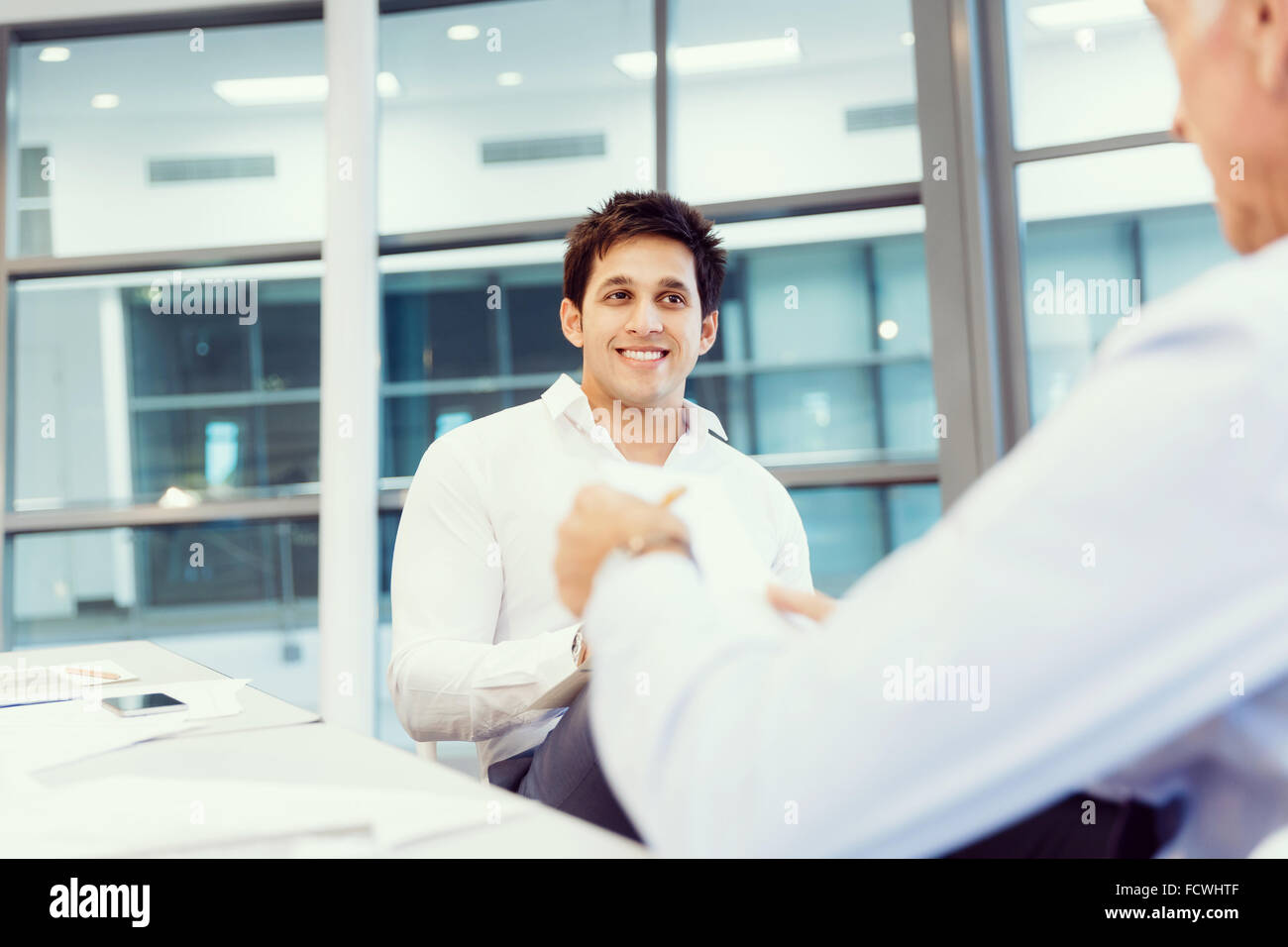 Two businessmen during interview in office Stock Photo - Alamy