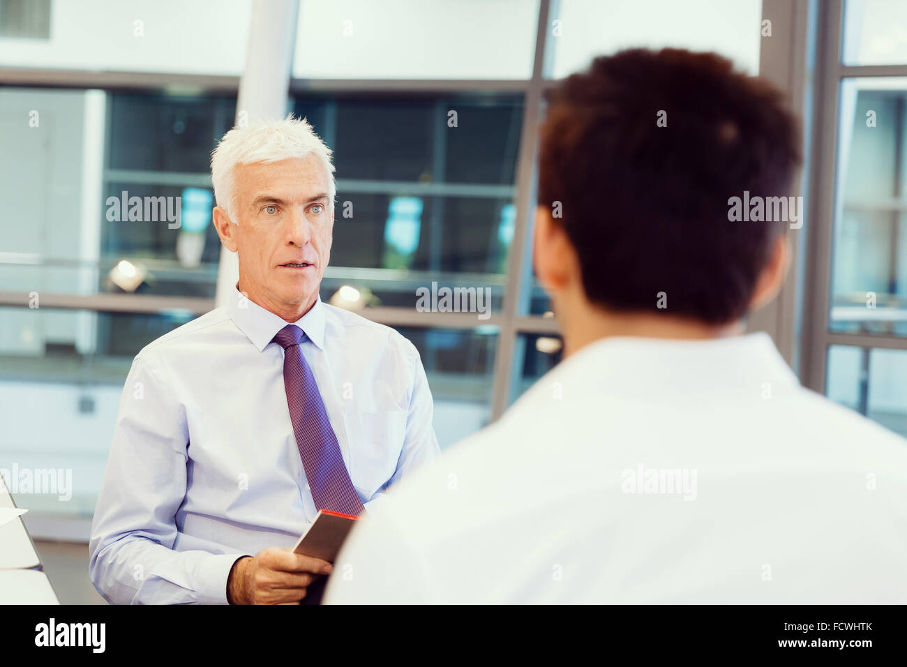 Two businessmen during interview in office Stock Photo - Alamy