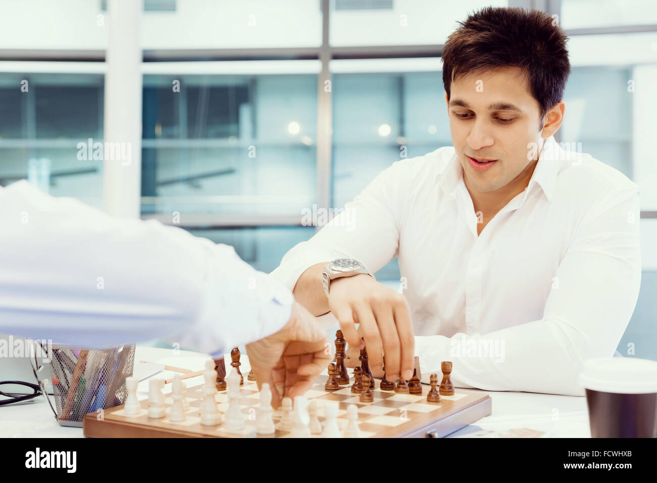 Two businessmen with chess in office Stock Photo - Alamy